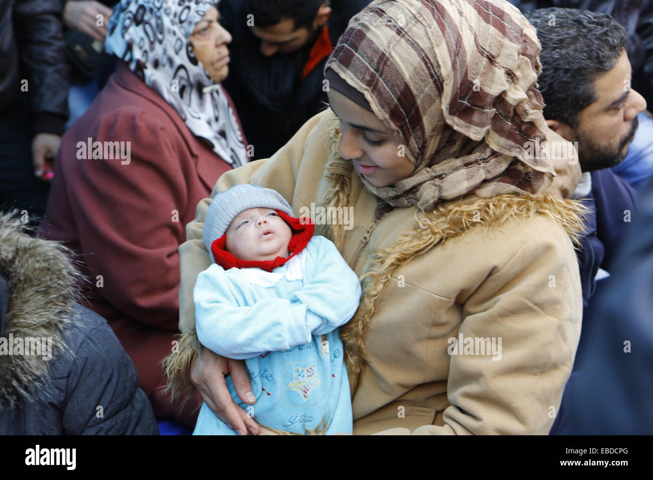 A Syrian woman holds a baby in her arms. The Syrian refugees who have ...