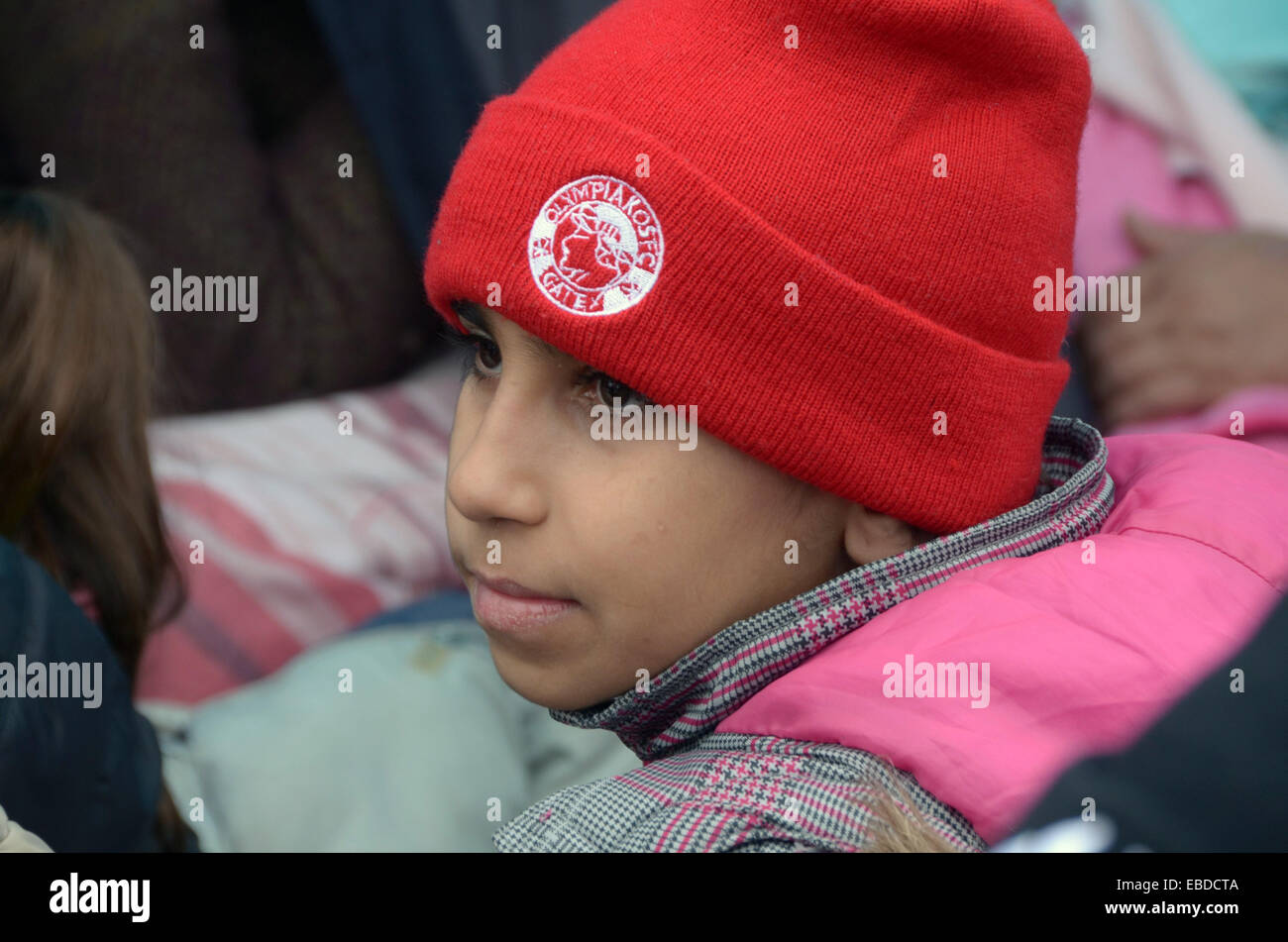 A young boy wears a red wool cap to protect his head from the cold ...