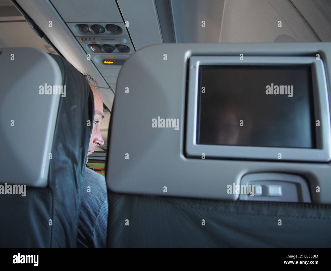 Man glancing out plane window during flight, USA, October 4, 2014 ...