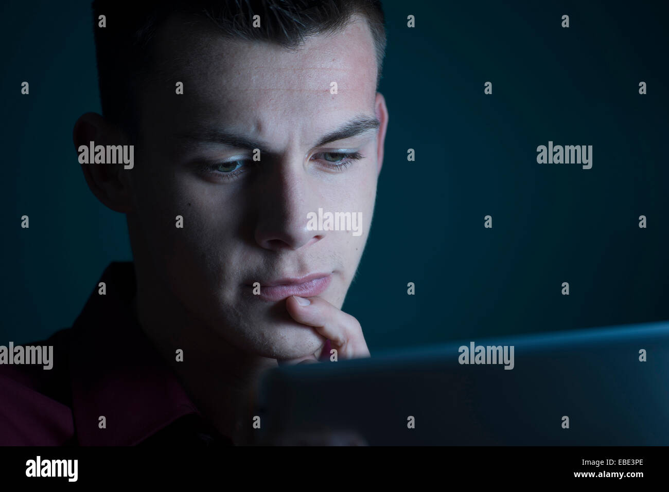 Young Man looking at Tablet Computer, Studio Shot Stock Photo - Alamy