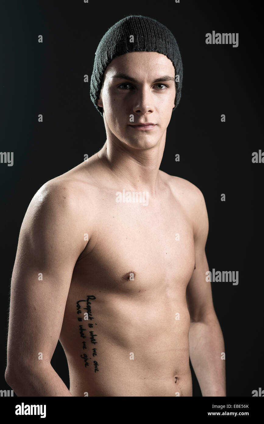 Close-up portrait of young man wearing toque, studio shot on black ...