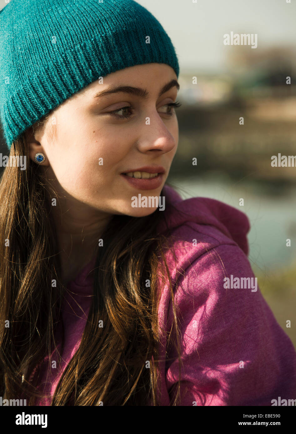 Close-up portrati of teenage girl outdoors wearing toque, looking to ...