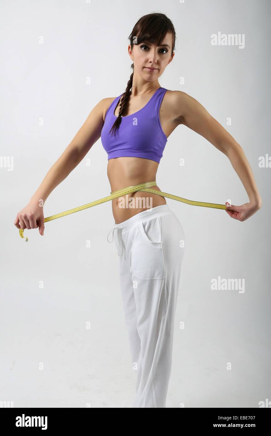 Beautiful woman measuring her waist Stock Photo - Alamy