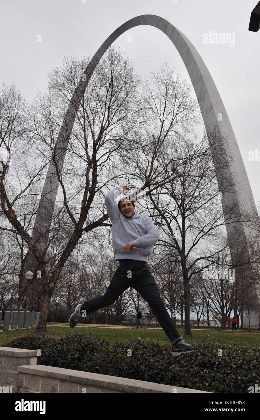 A young man jumping in front of the Gateway Arch Monument in St Louis ...
