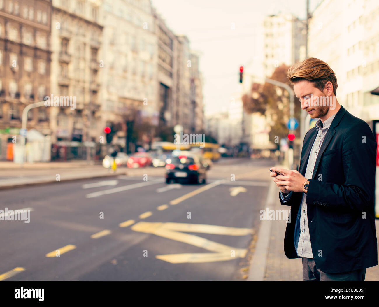 Young man on the street with mobile phone Stock Photo - Alamy
