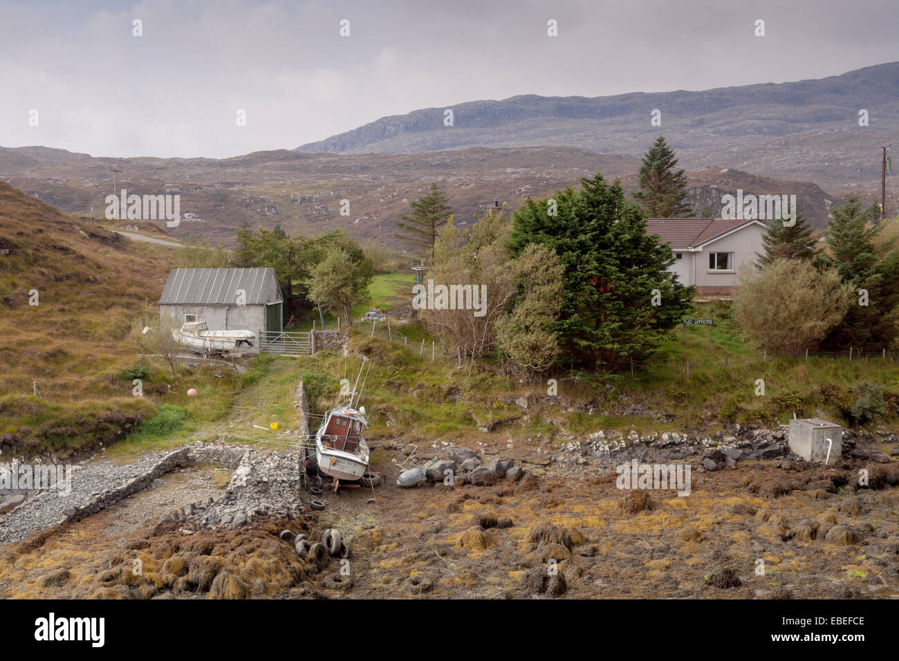 Fishing boat on slipway next to cottage, Loch Stocinis, Isle of Harris ...