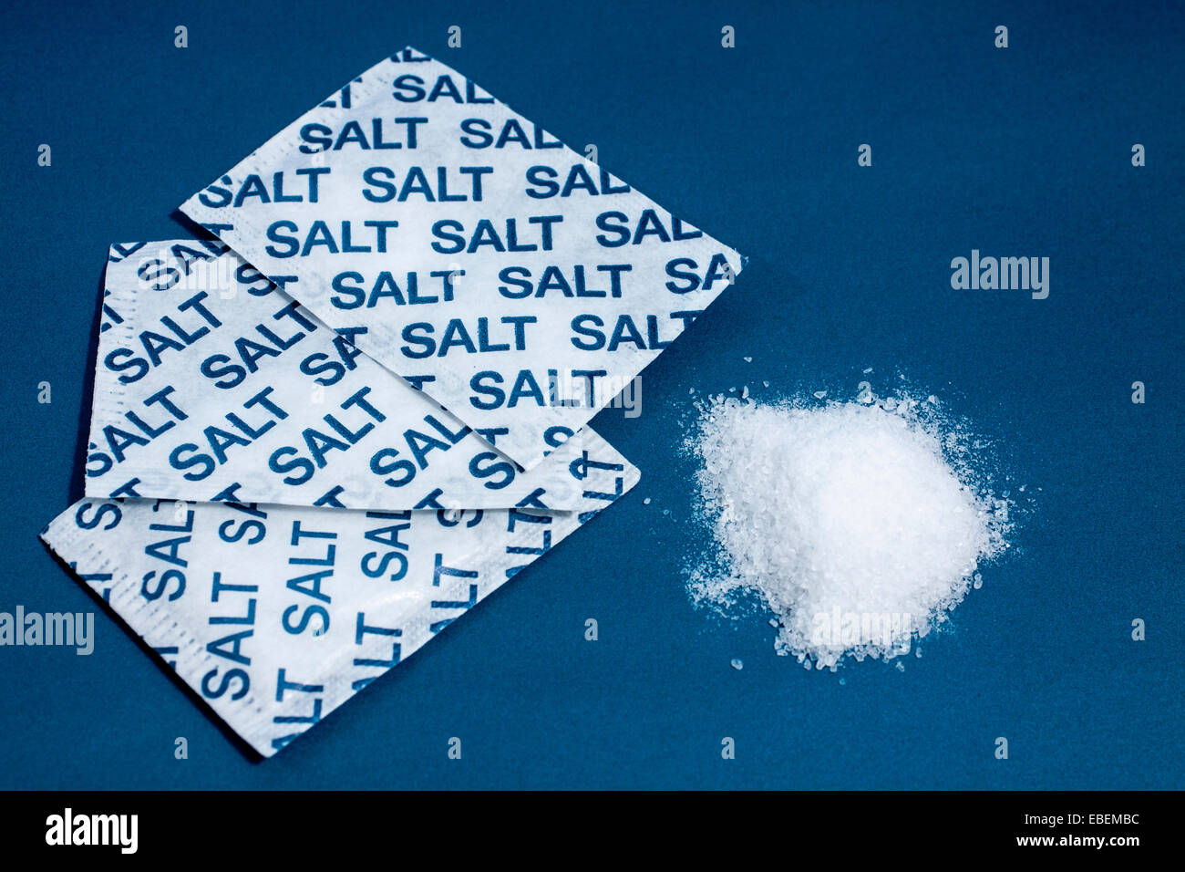 Salt sachets on a blue background Stock Photo - Alamy