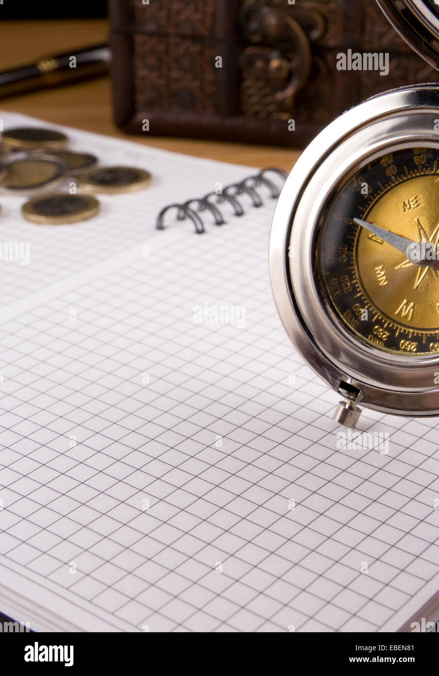 silver compass, gold coin and notebook Stock Photo - Alamy