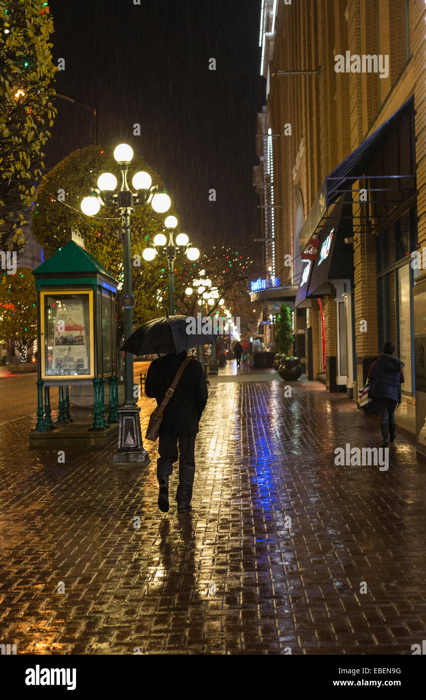 Man walking in downtown Victoria on rainy night-Victoria, British ...