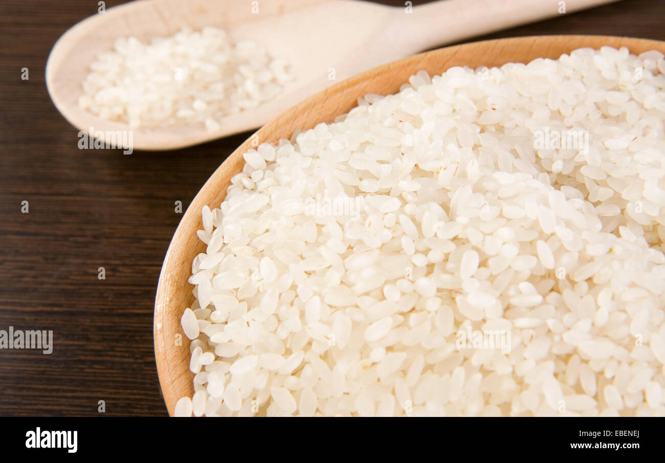 rice and plate with wooden spoon on table Stock Photo - Alamy