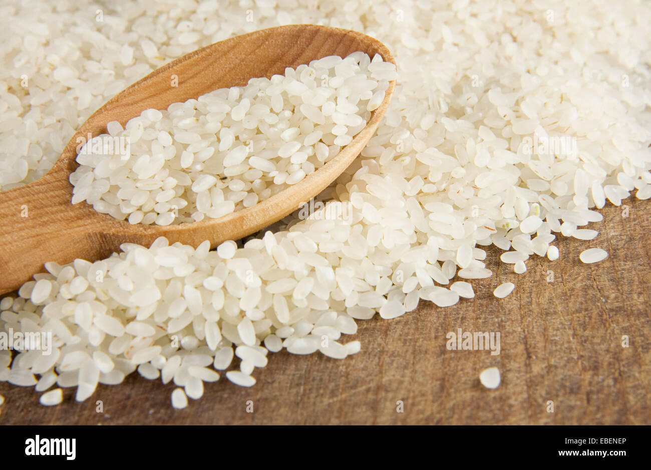 rice grain in wooden spoon on table Stock Photo - Alamy