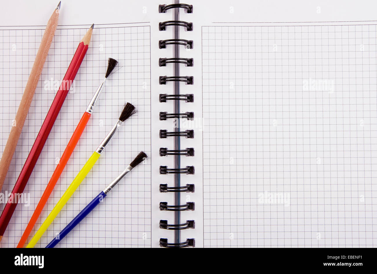 brush and pencils on checked notebook Stock Photo - Alamy