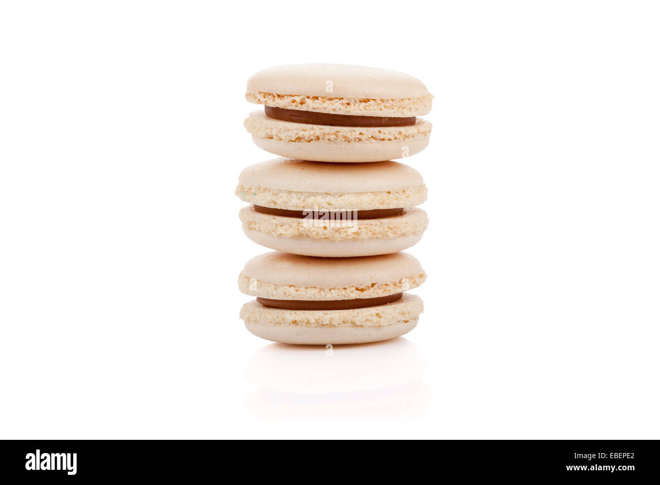 Three delicious beige colored macaroons isolated on white background ...