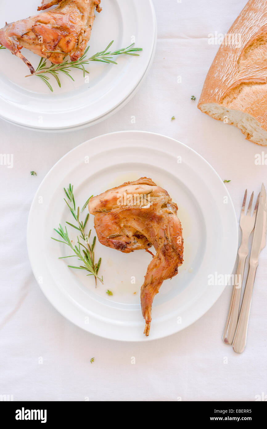 Plates of baked rabbit with rosemary and olive oil. Traditional ...