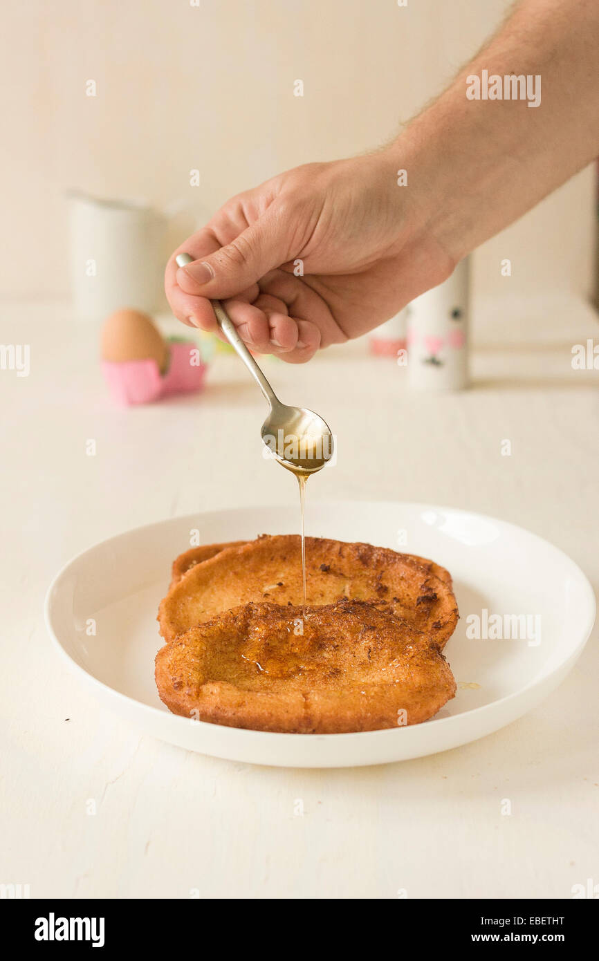 Pouring honey over pudding Stock Photo - Alamy