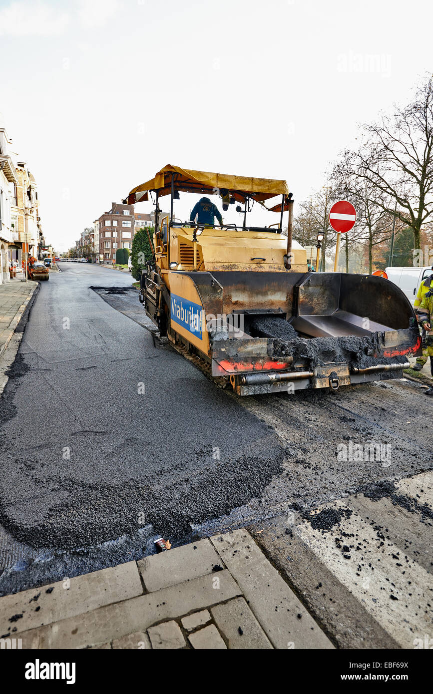 An asphalt spreader is used to place layer of asphalt and steam roller ...