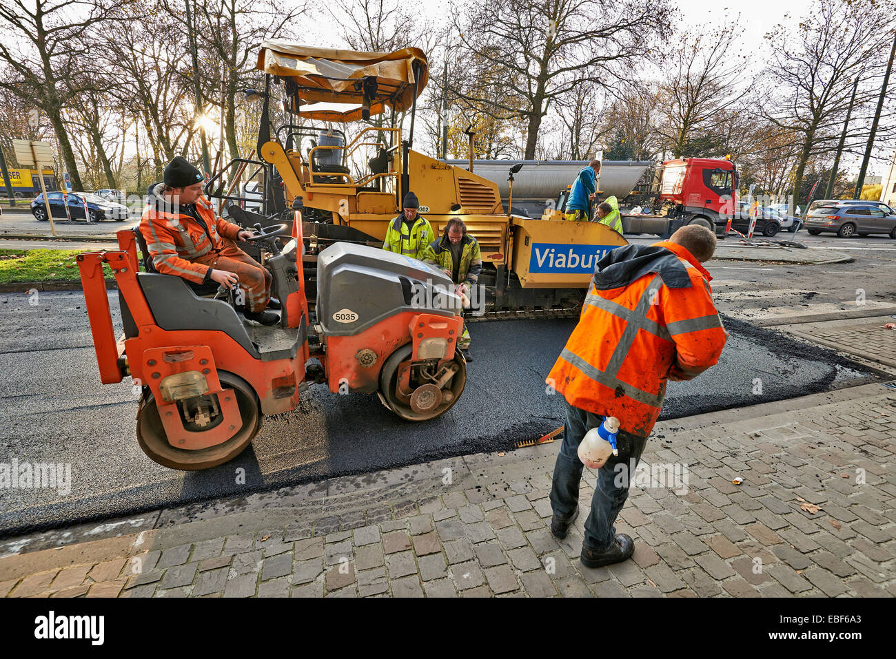An asphalt spreader is used to place layer of asphalt and steam roller ...