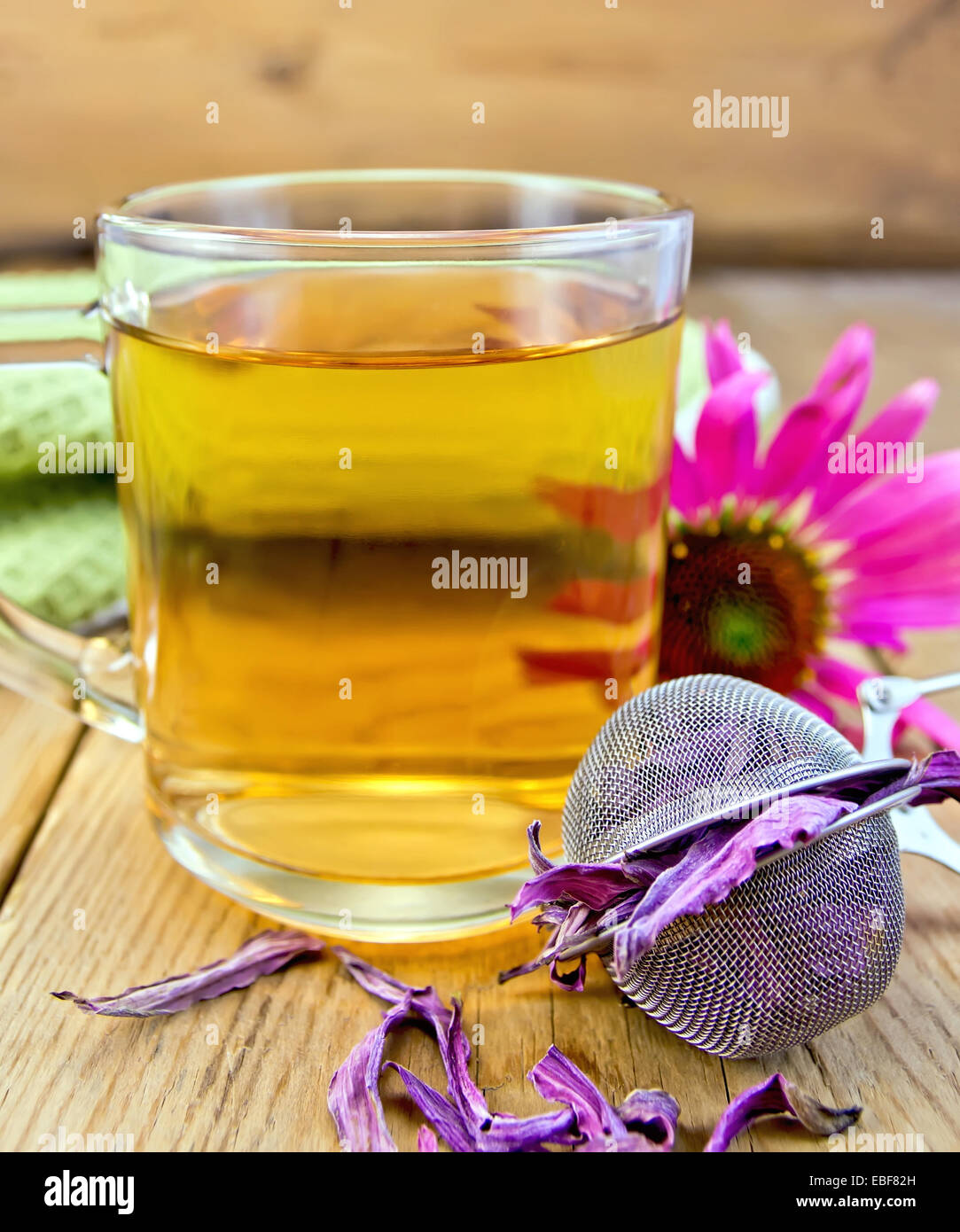 Tea from Echinacea in glass mug with strainer on board Stock Photo - Alamy