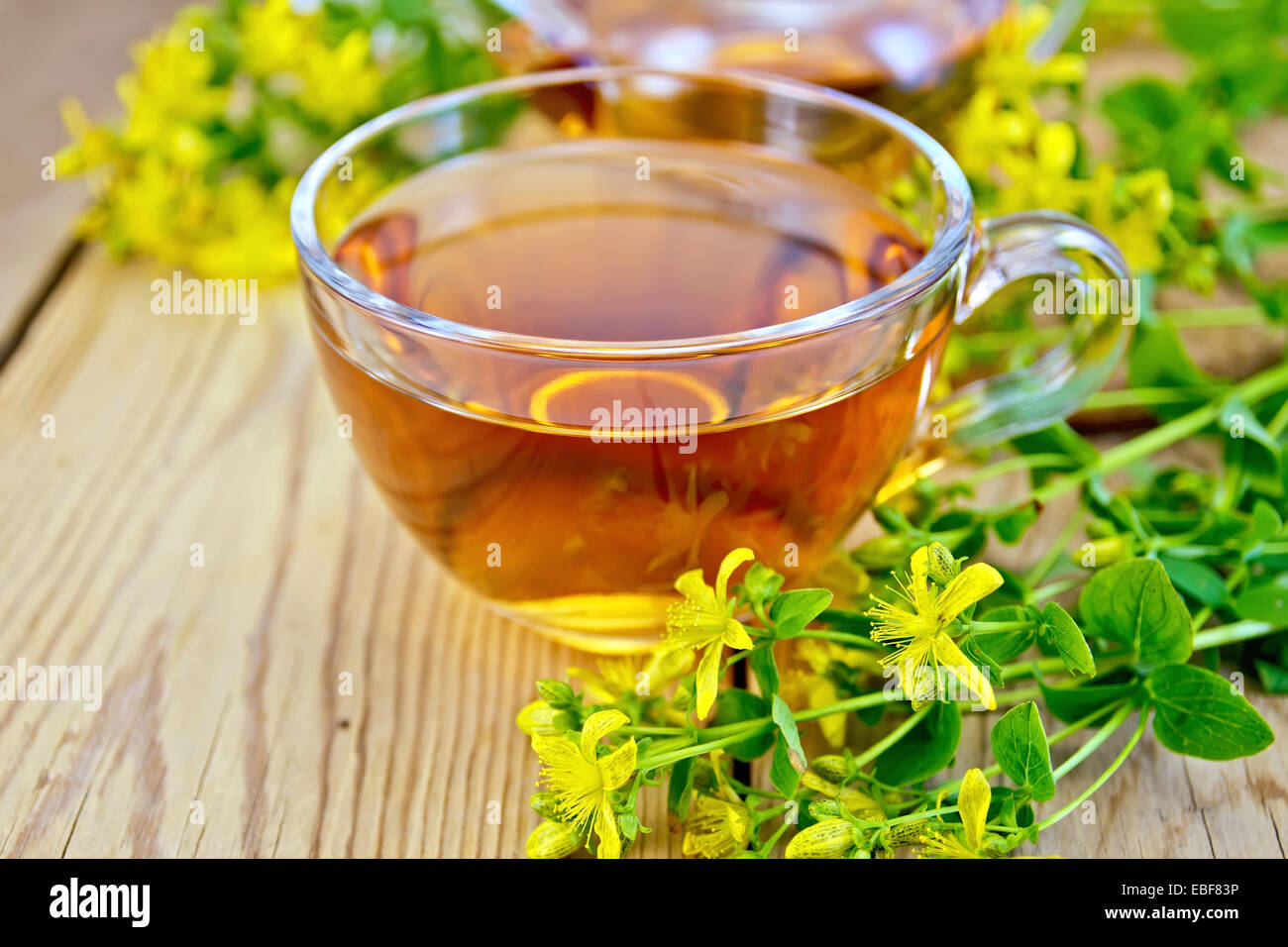 Tea from tutsan in glass cup on board Stock Photo - Alamy