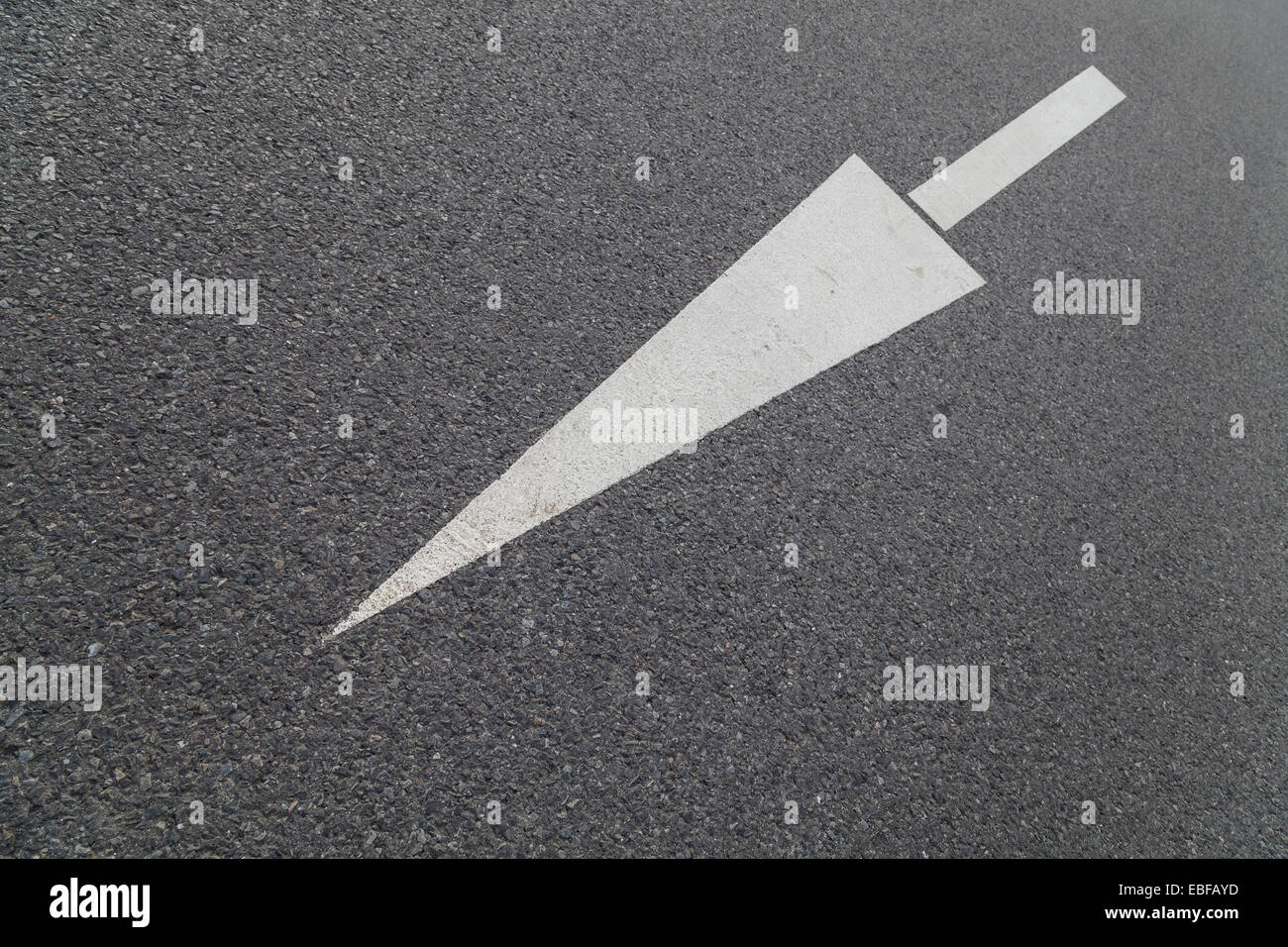 arrow in one direction on asphalt Stock Photo - Alamy