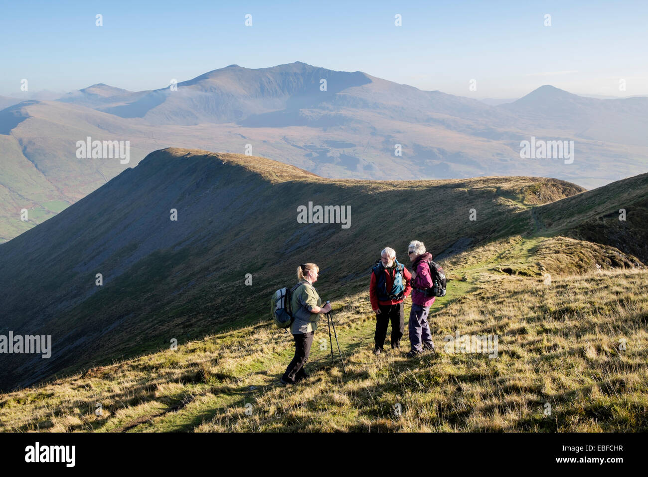 Hikers hiking on Mynydd Mawr ridge with view to Mount Snowdon in ...