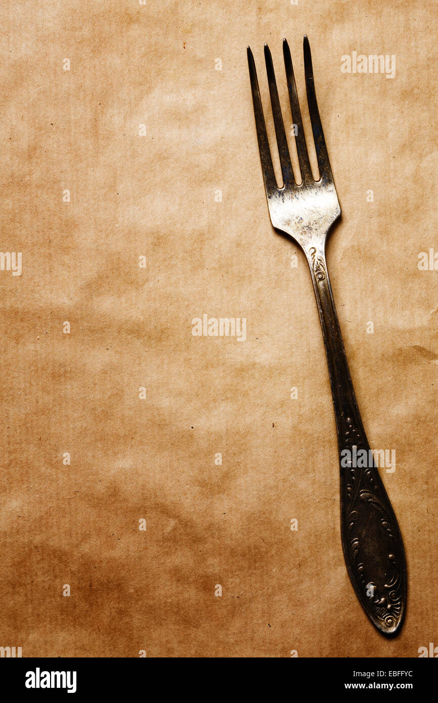 Old fork on craft paper background. Vintage silverware Stock Photo - Alamy