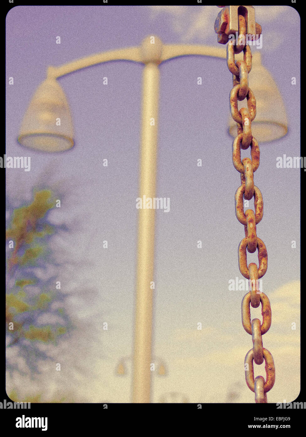 Rusty swing chain and street lights in the background Stock Photo - Alamy