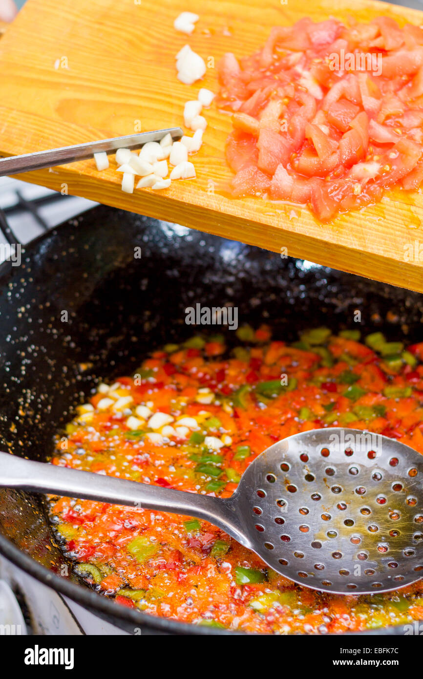 Frying ingredients to make a traditional spanish paella Stock Photo - Alamy