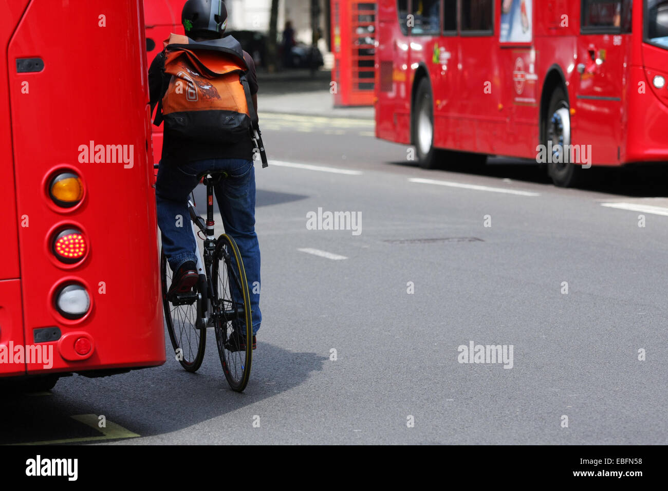 A cyclist overtaking a stationary red London bus Stock Photo - Alamy