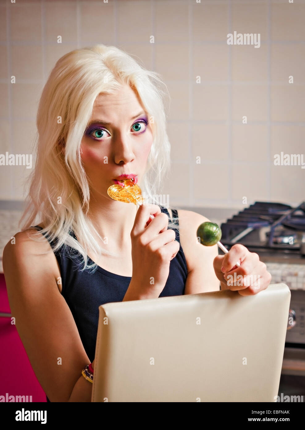 Portrait of a beautiful blonde girl with two candies in hands Stock ...