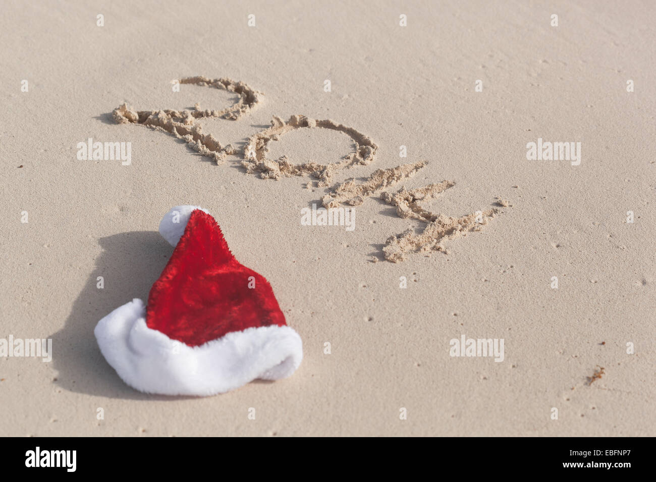 Santa Hat and 2014 numbers writing on white sandy beach Stock Photo - Alamy