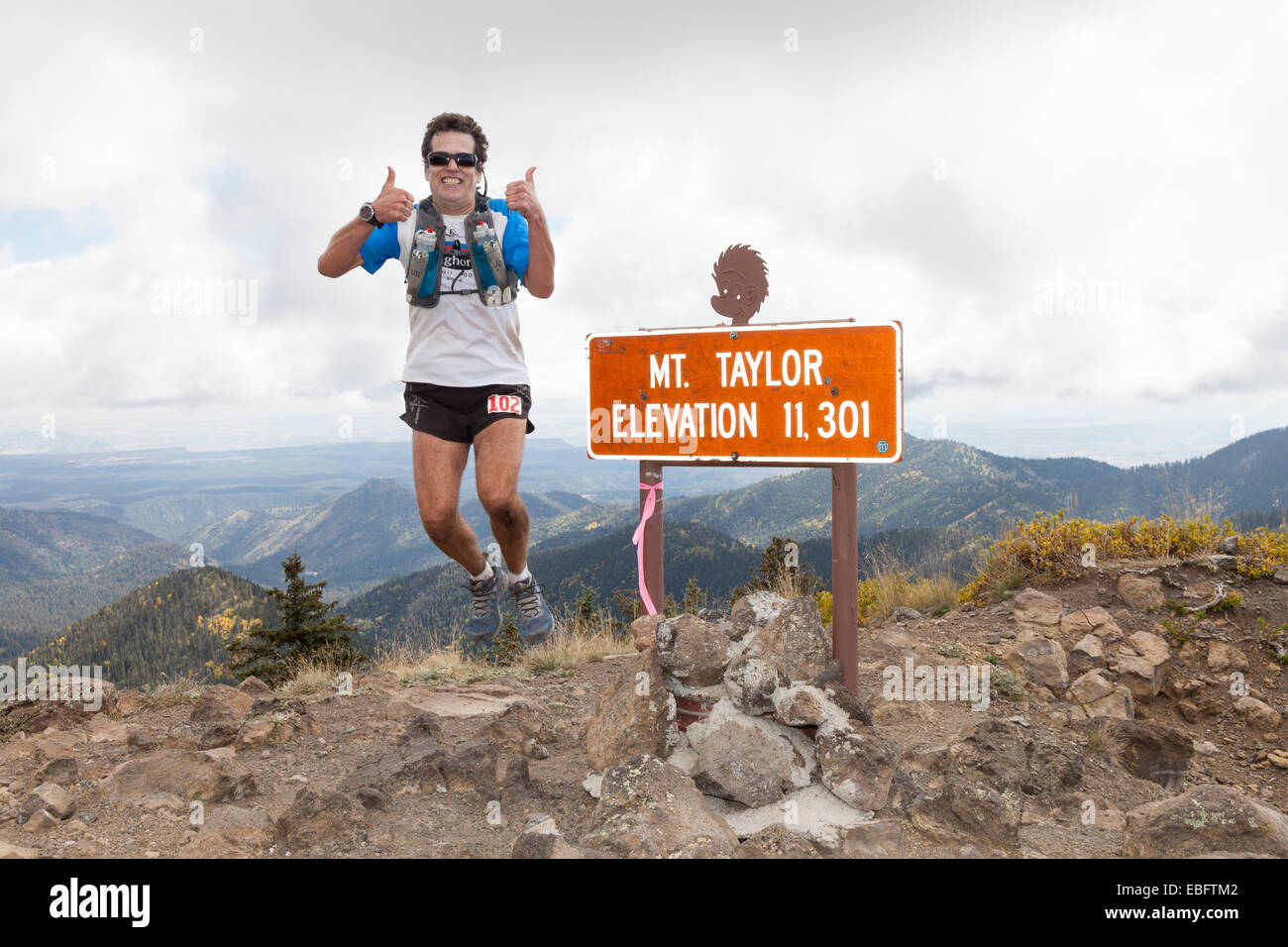 Runner reaches the summit during the Mt Taylor 50k Stock Photo - Alamy