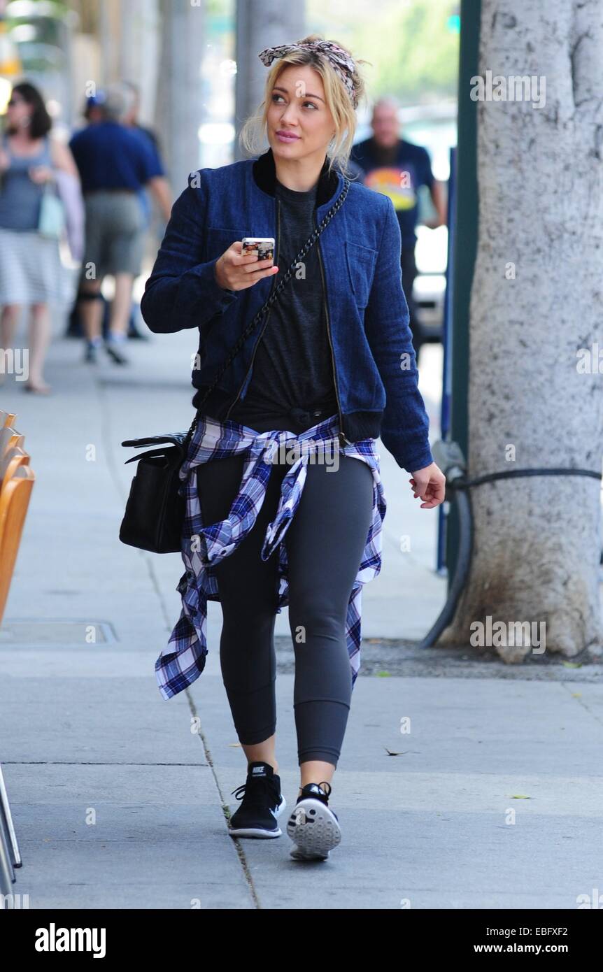 Hilary Duff wearing a blue checked shirt around her waist and walking in Nike trainers, goes to ...