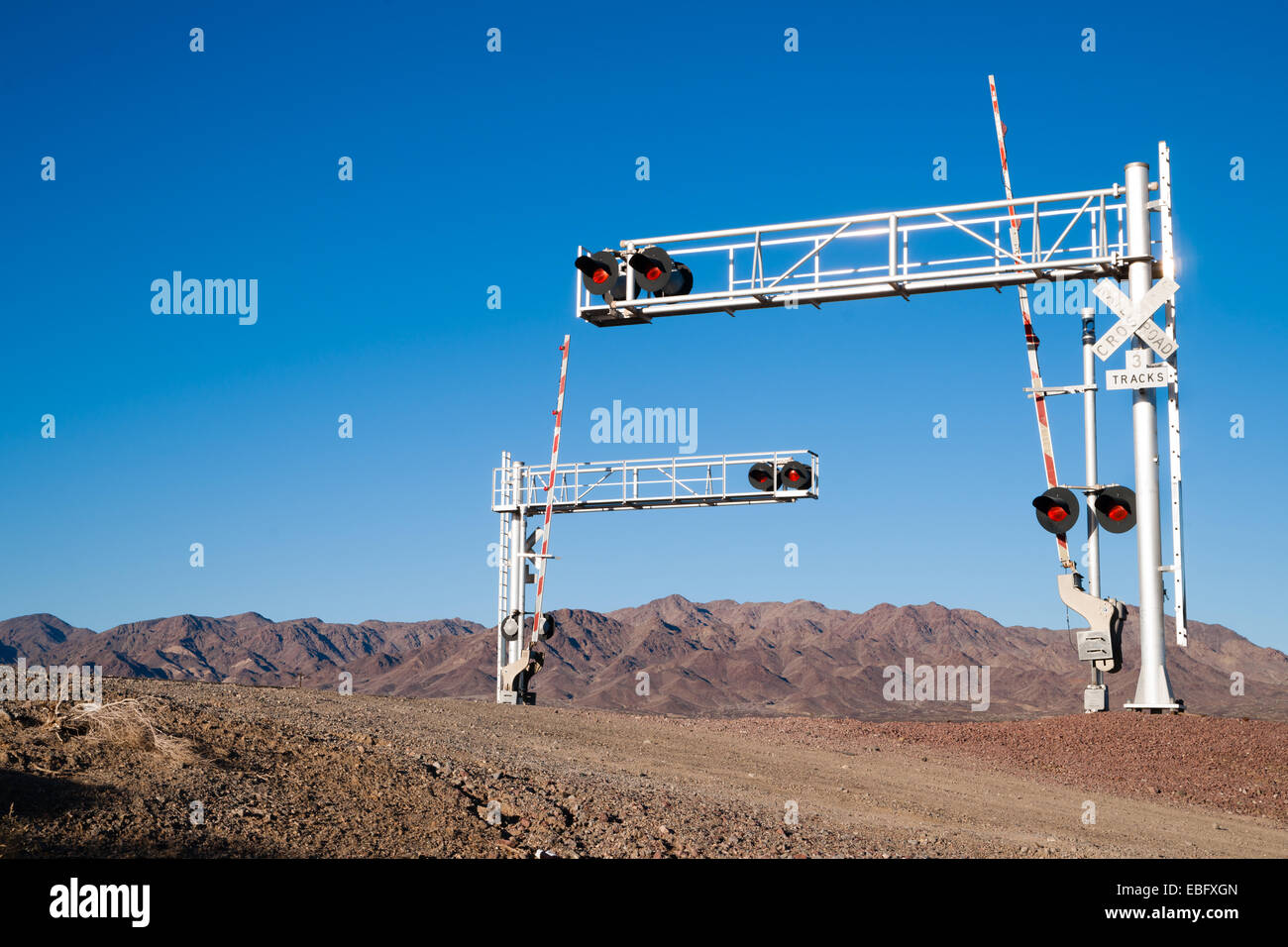 A busy railroad crossing in front of desert mountains Stock Photo - Alamy