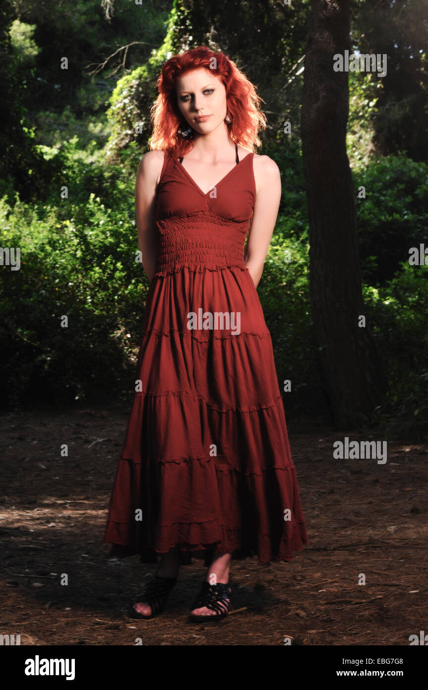 Red dresses woman in a forest Stock Photo - Alamy