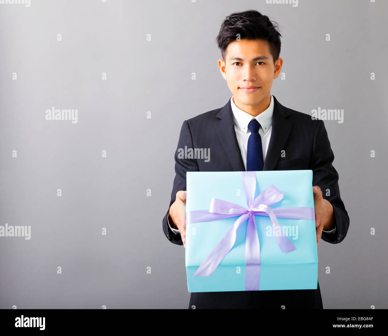 Young man giving gift box hi-res stock photography and images - Alamy