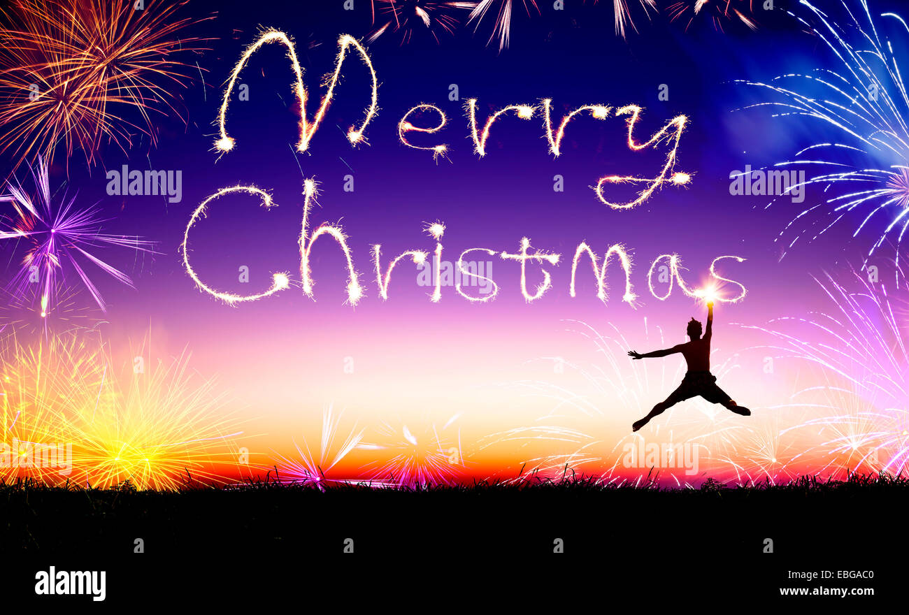 young man jumping and drawing the merry christmas Stock Photo - Alamy