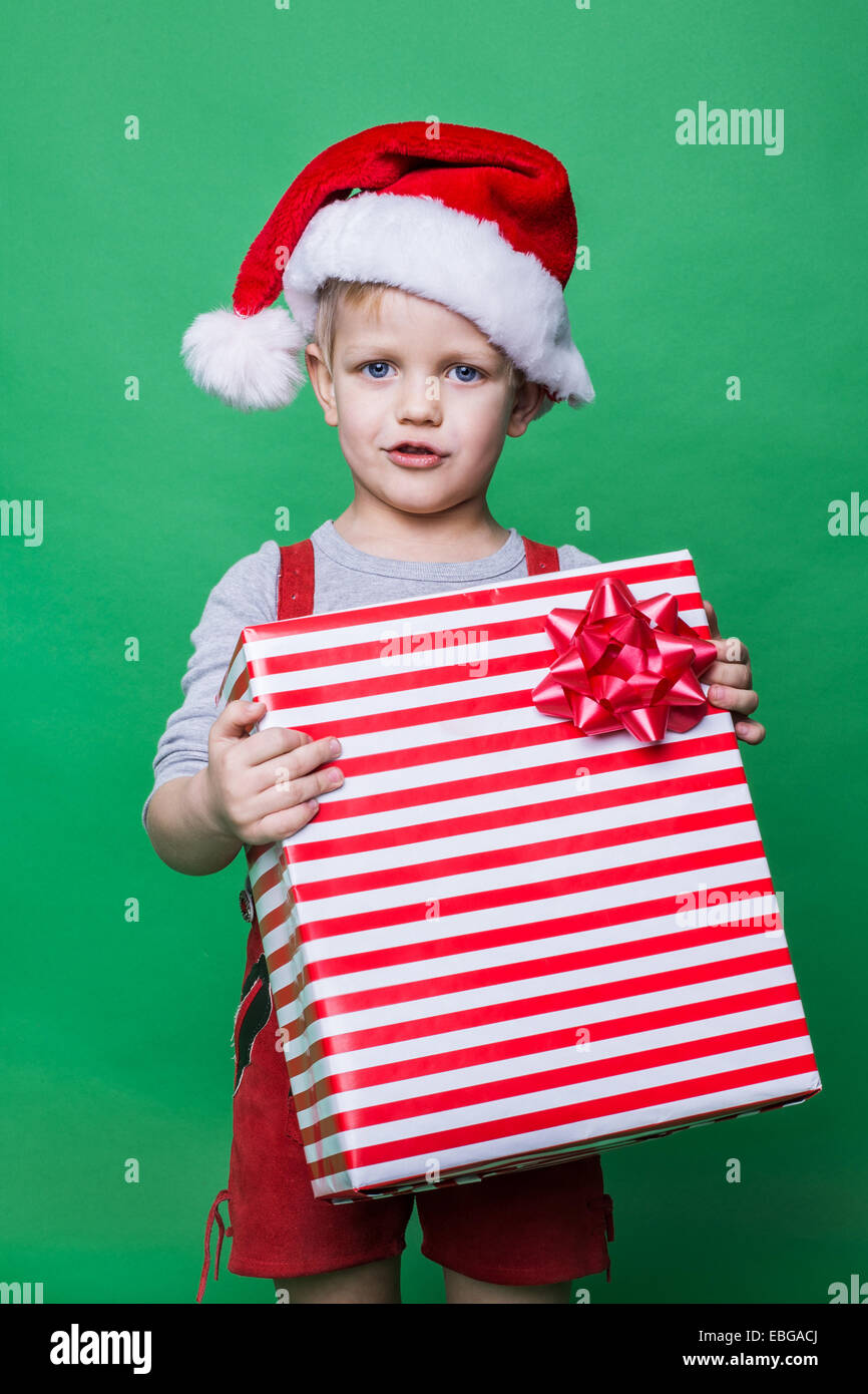 Christmas Elf holding big red gift box with ribbon. Santa Claus helper ...