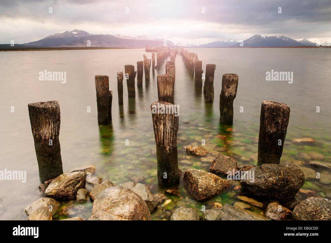 Old pillars of a jetty, Isla Diego Portales at back, Puerto Natales ...