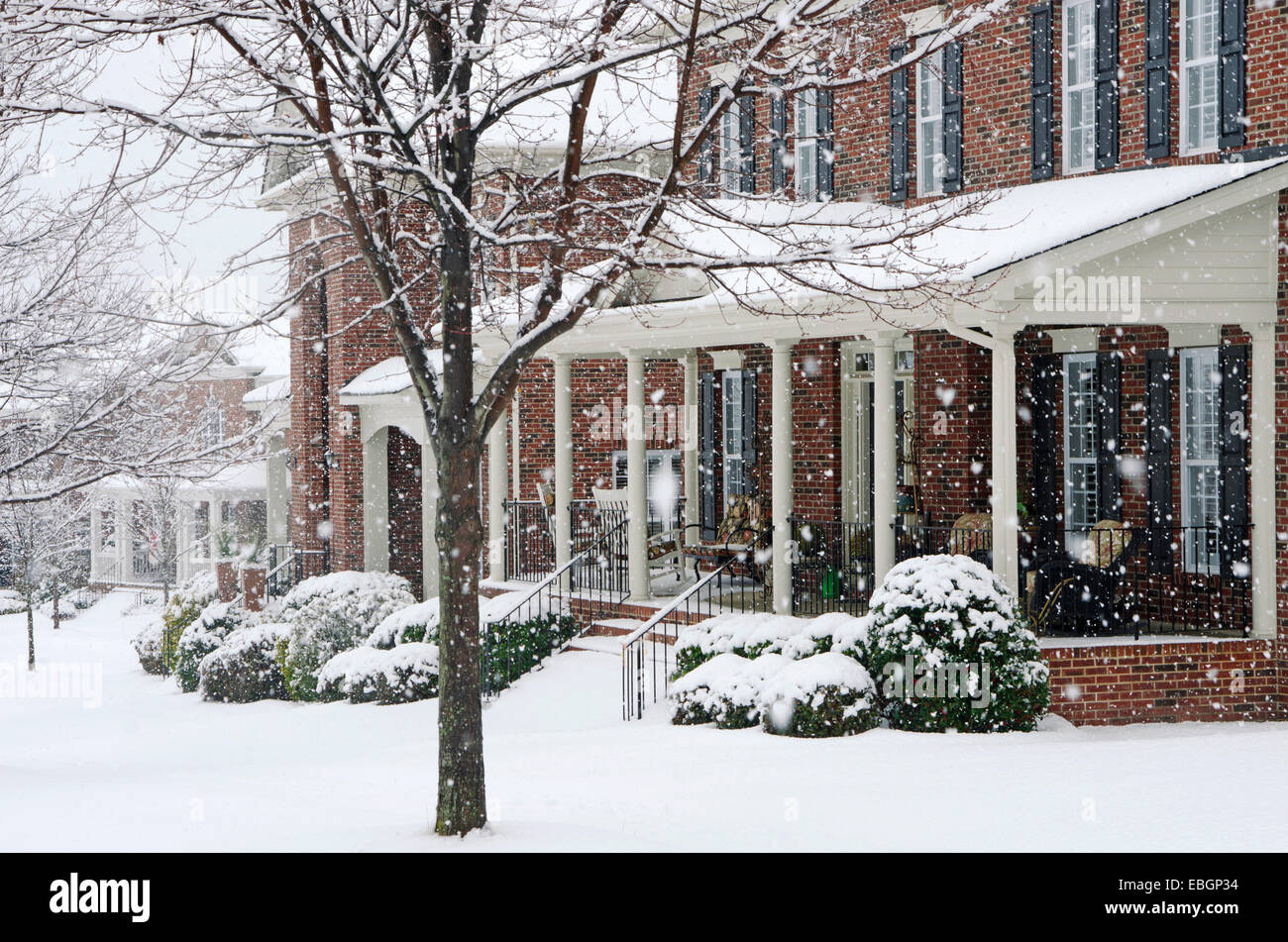 A traditional, brick home is captured during a snow storm in this ...