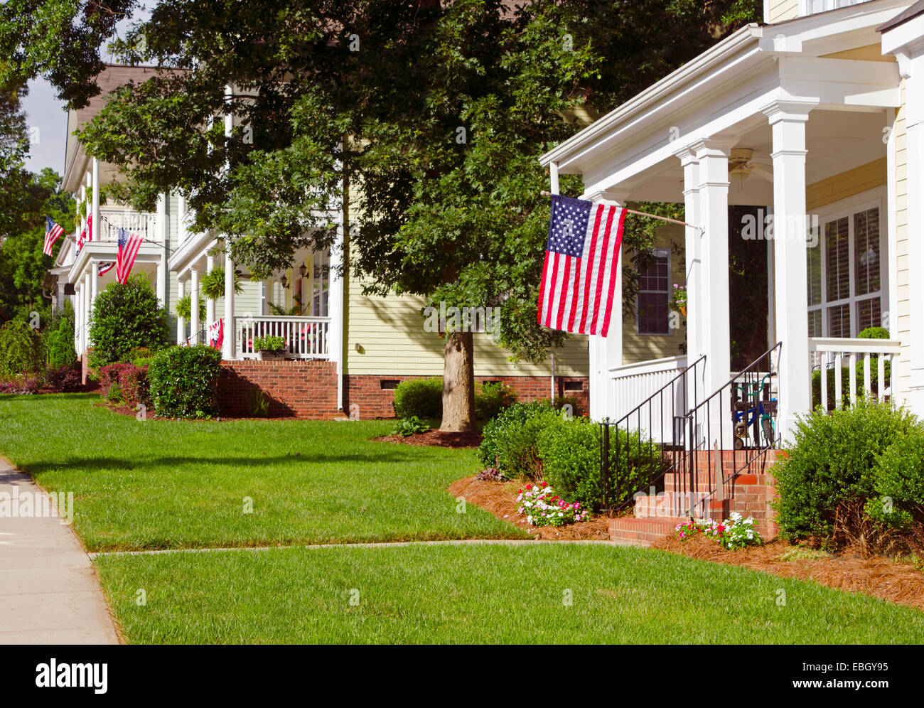 An American Flag hangs from a front porch in a neighborhood of ...