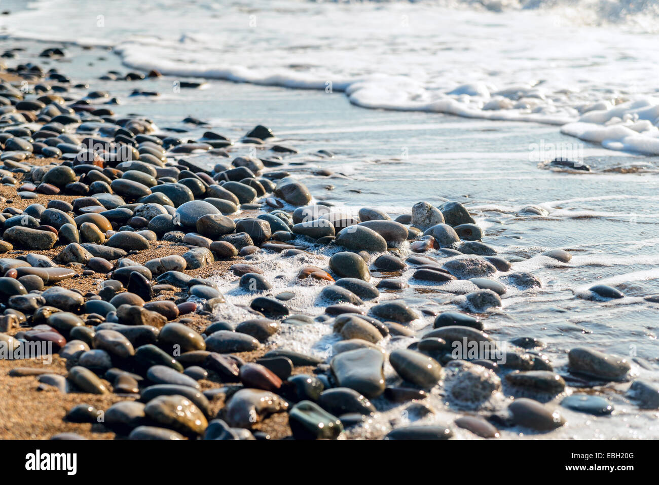 Beach, sea pebbles washed by the waves at sunrise Stock Photo - Alamy