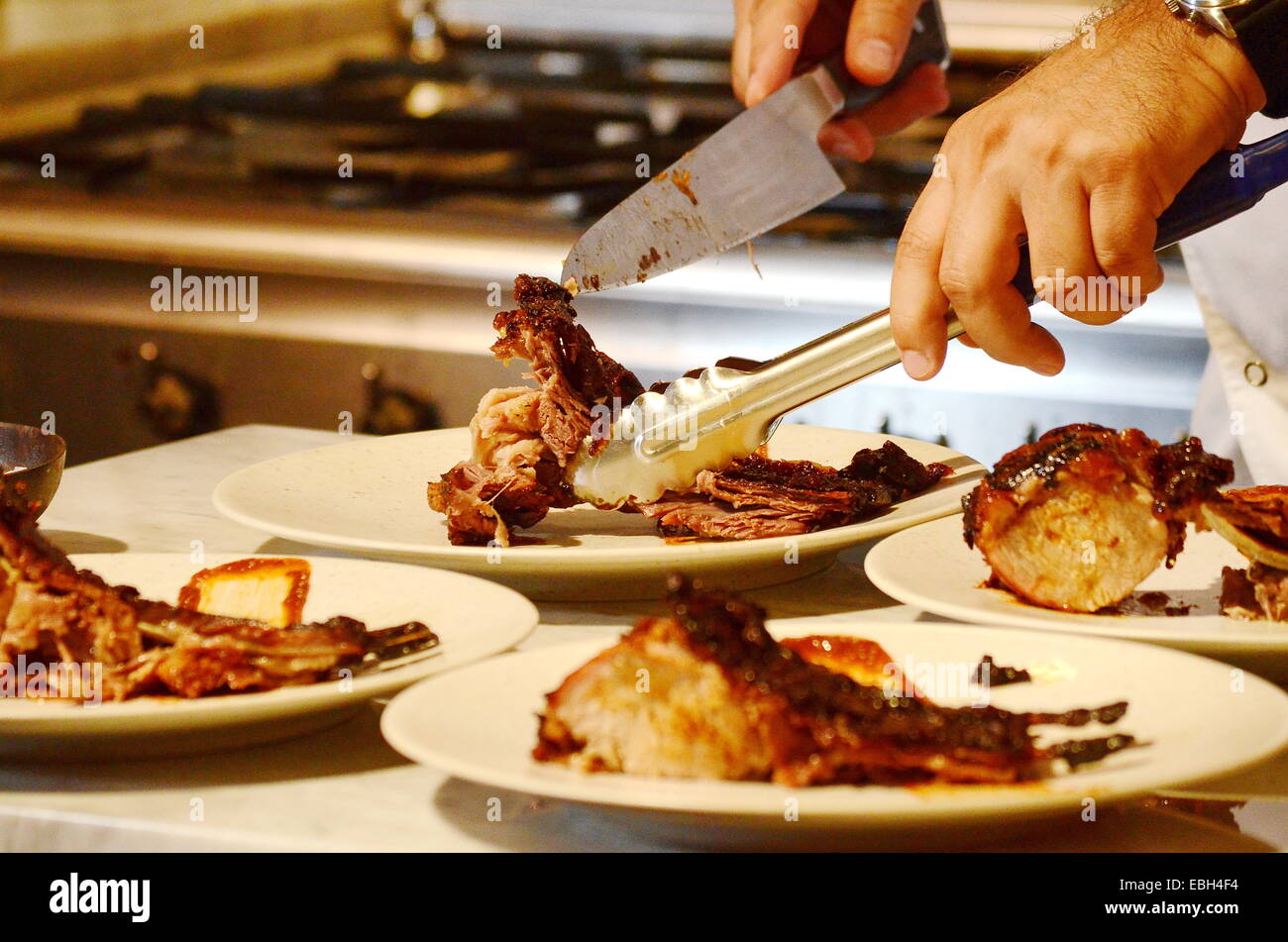 Chef's hands cutting and serving wild boar ribs Stock Photo - Alamy