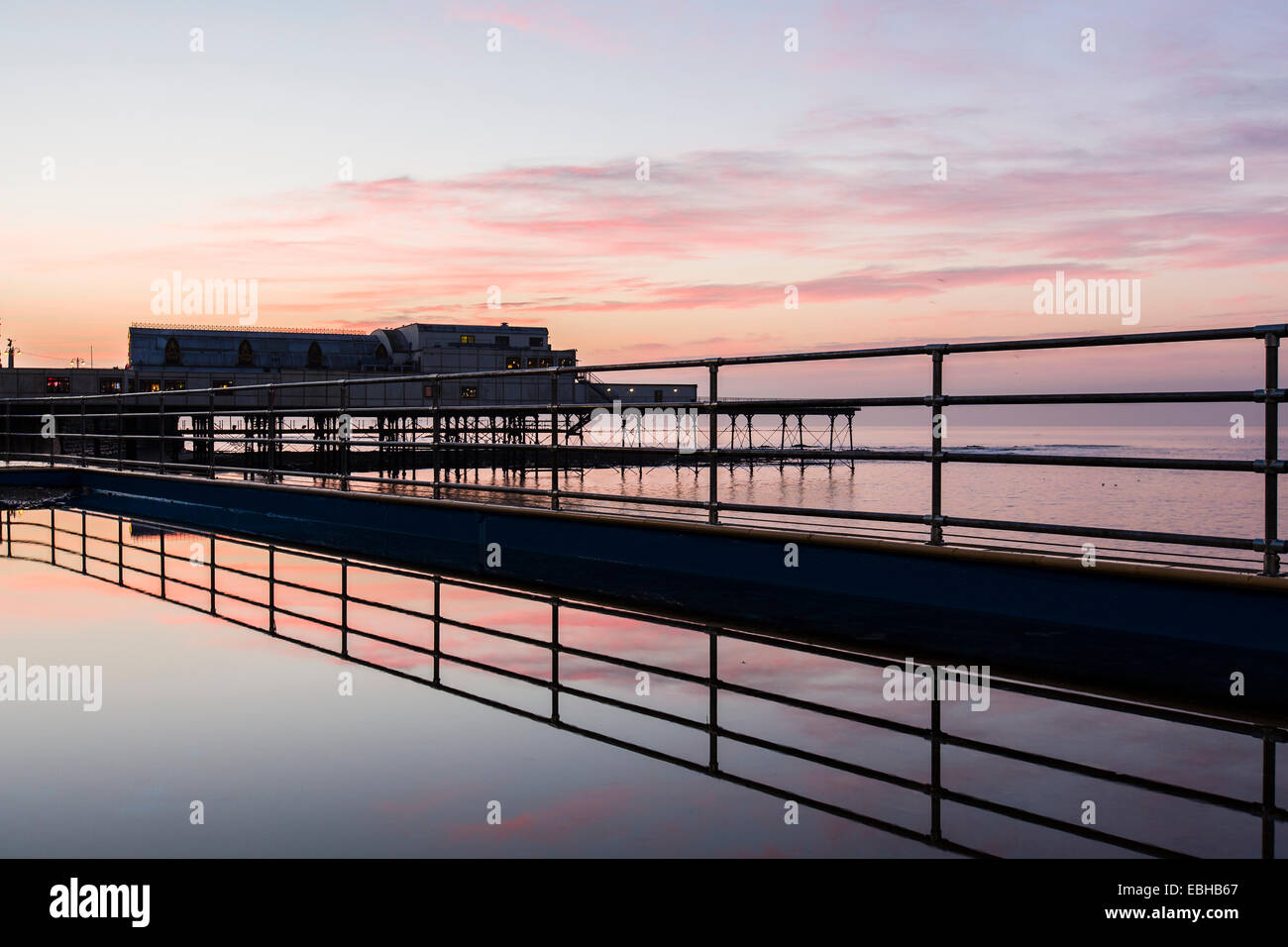 The sunsets behind the Royal Pier at Aberystwyth reflected in the ...