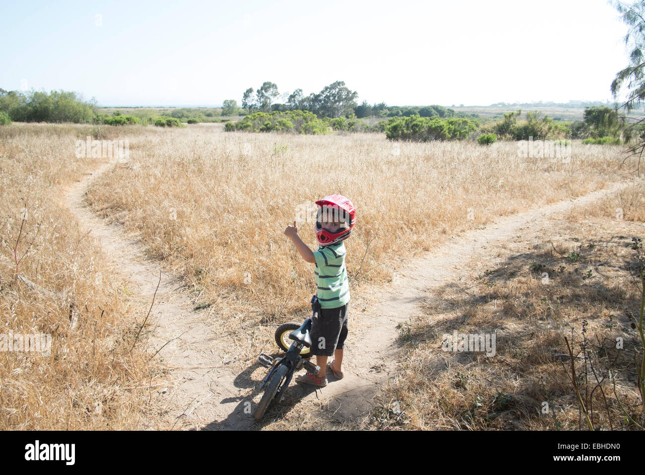 Young boy on path in field with bike Stock Photo - Alamy