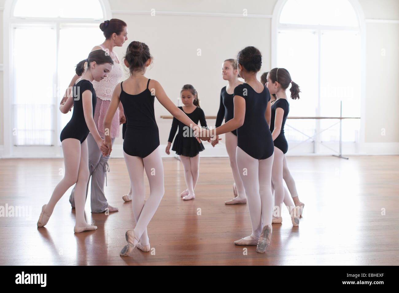 Ballet teacher holding hands with group of ballet school girls Stock ...