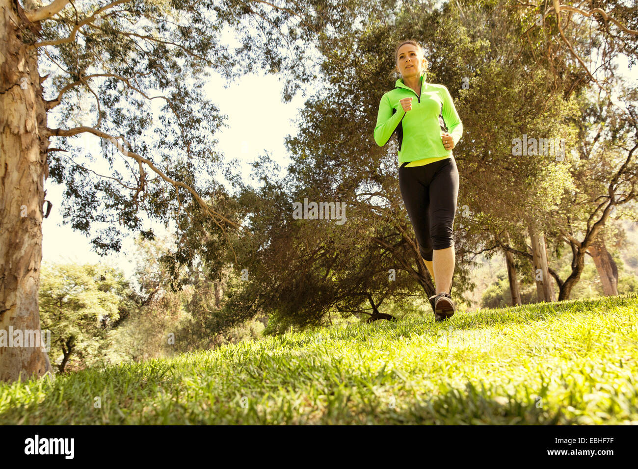 Mature woman running through park Stock Photo - Alamy