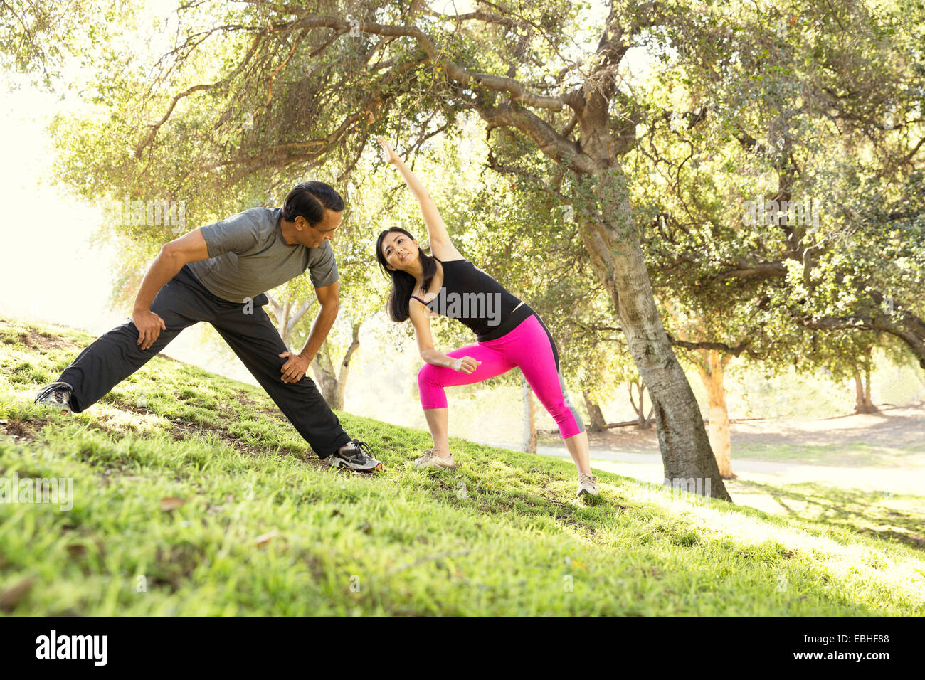 Mature running couple warming up together in park Stock Photo - Alamy