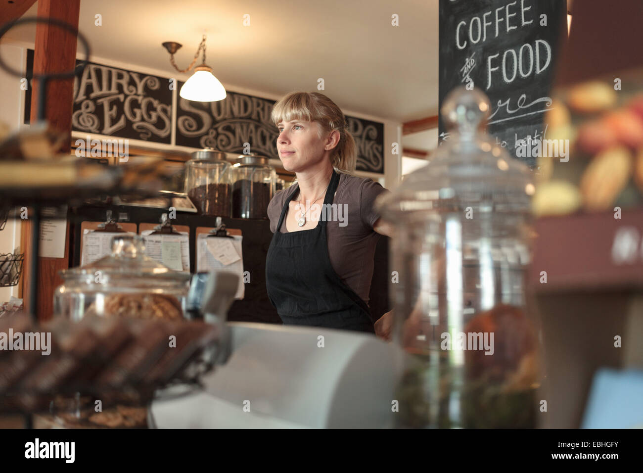 Female shop assistant in country store cafe Stock Photo - Alamy
