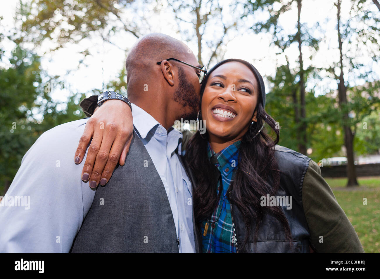 Man kissing woman's cheek in park Stock Photo - Alamy